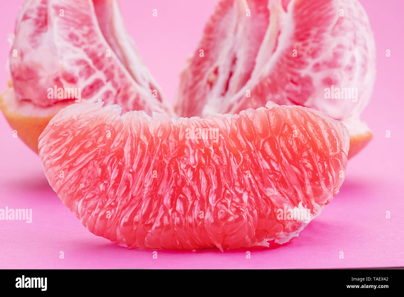 Peeled grapefruit slice isolated on pink background Stock Photo - Alamy
