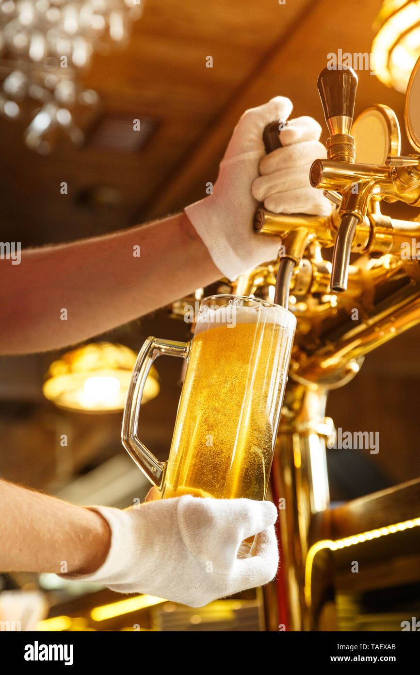 Bartender hands pouring light beer in a beer glass Stock Photo - Alamy