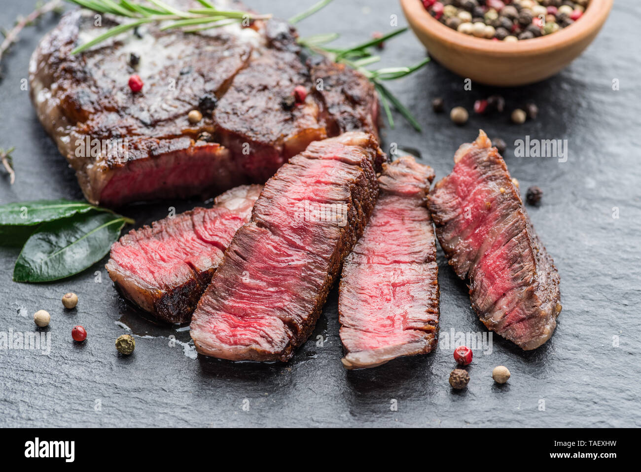 Medium rare Ribeye steak with herbs on graphite board Stock Photo - Alamy
