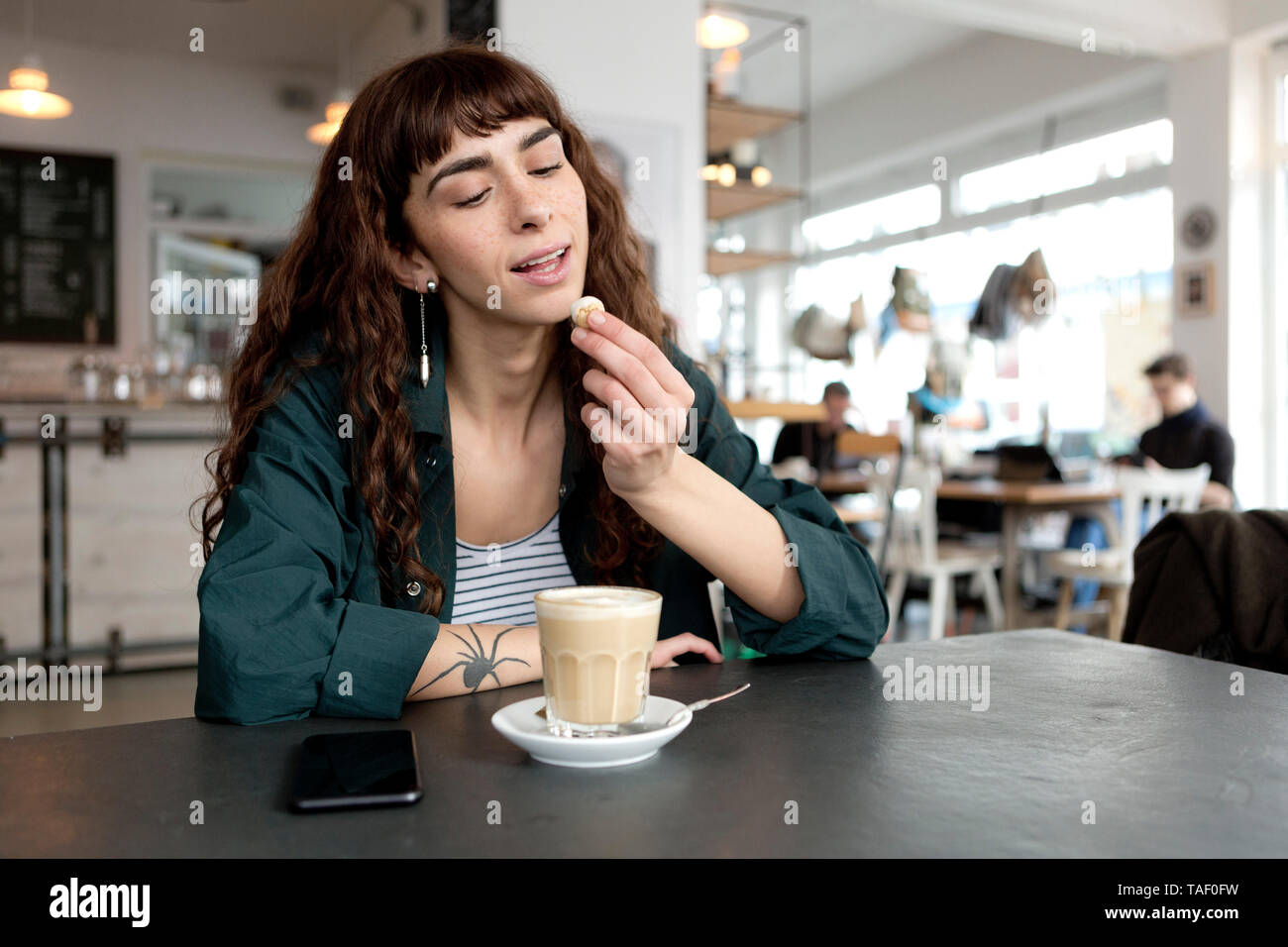 Woman sitting at a cafe table hi-res stock photography and images - Alamy