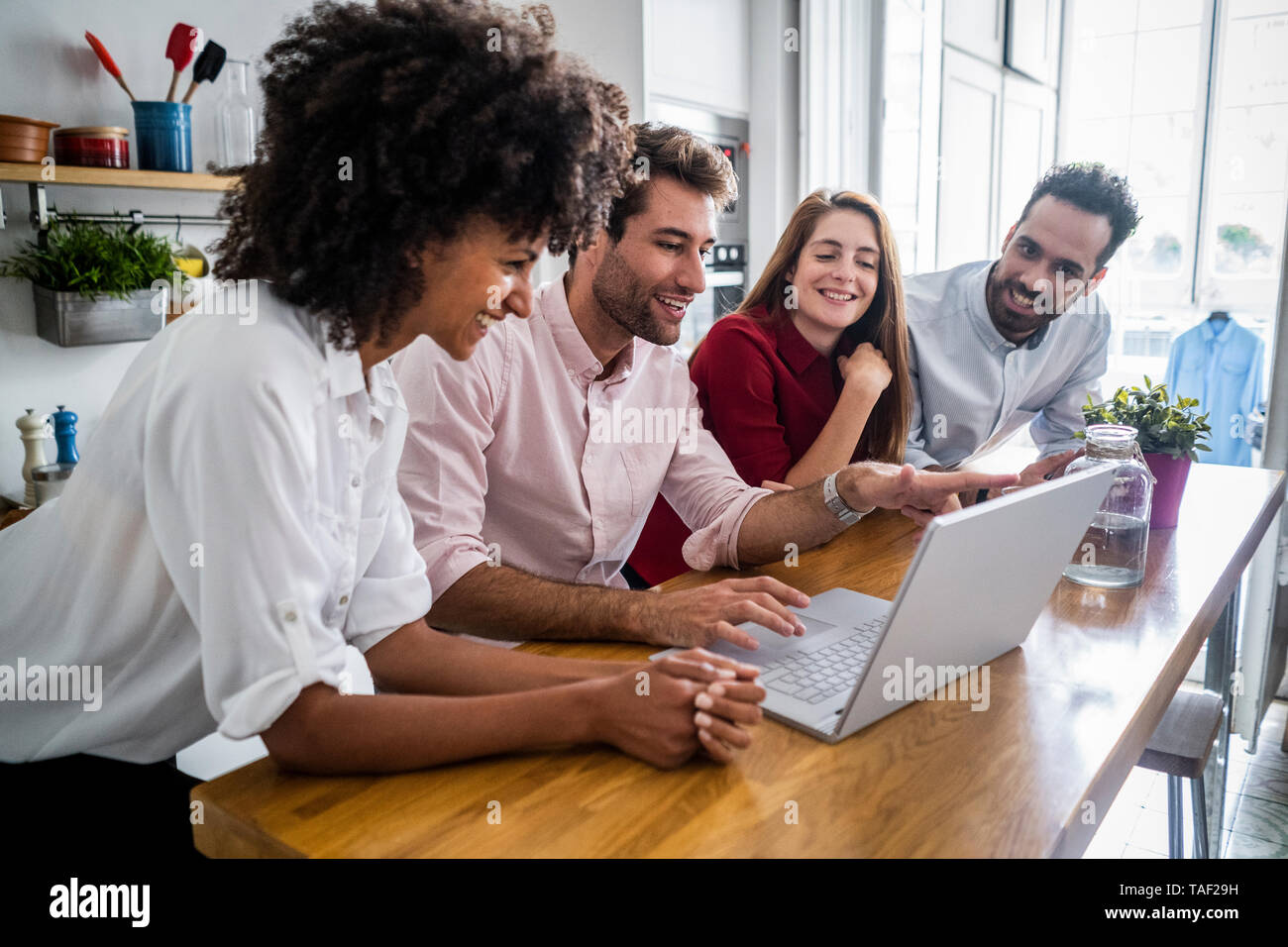 Friends working together on a project in their loft office Stock Photo ...