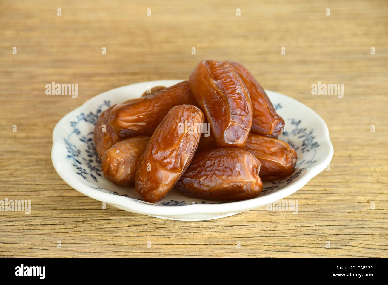 Dried dates fruit in ceramic dish on old wood table Stock Photo - Alamy