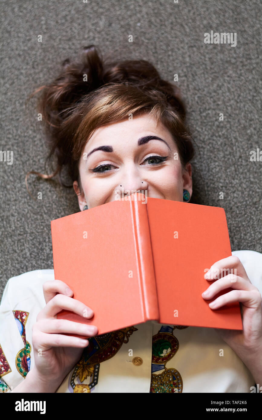 Female student reading book in a public library Stock Photo - Alamy