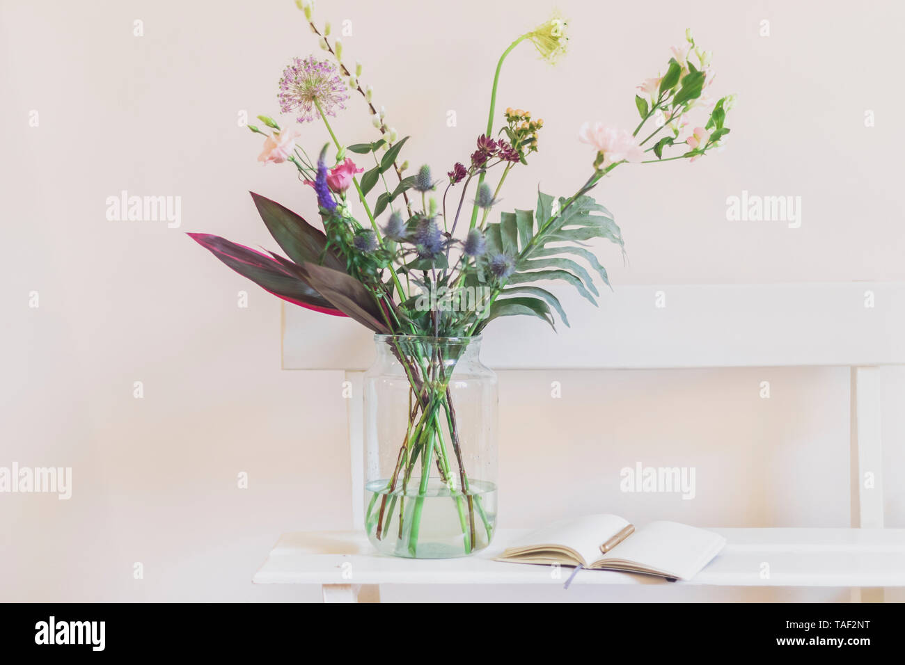 Flower vase and open calendar on white bench Stock Photo - Alamy