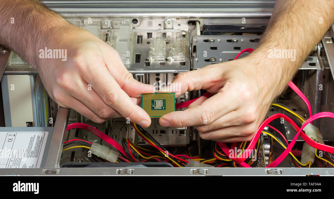 the CPU in the hands of men on the background of the open system unit ...