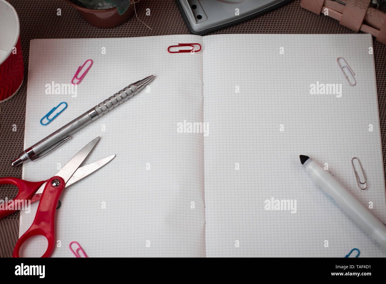 Scissors and writing equipments plus math book above textured backdrop ...