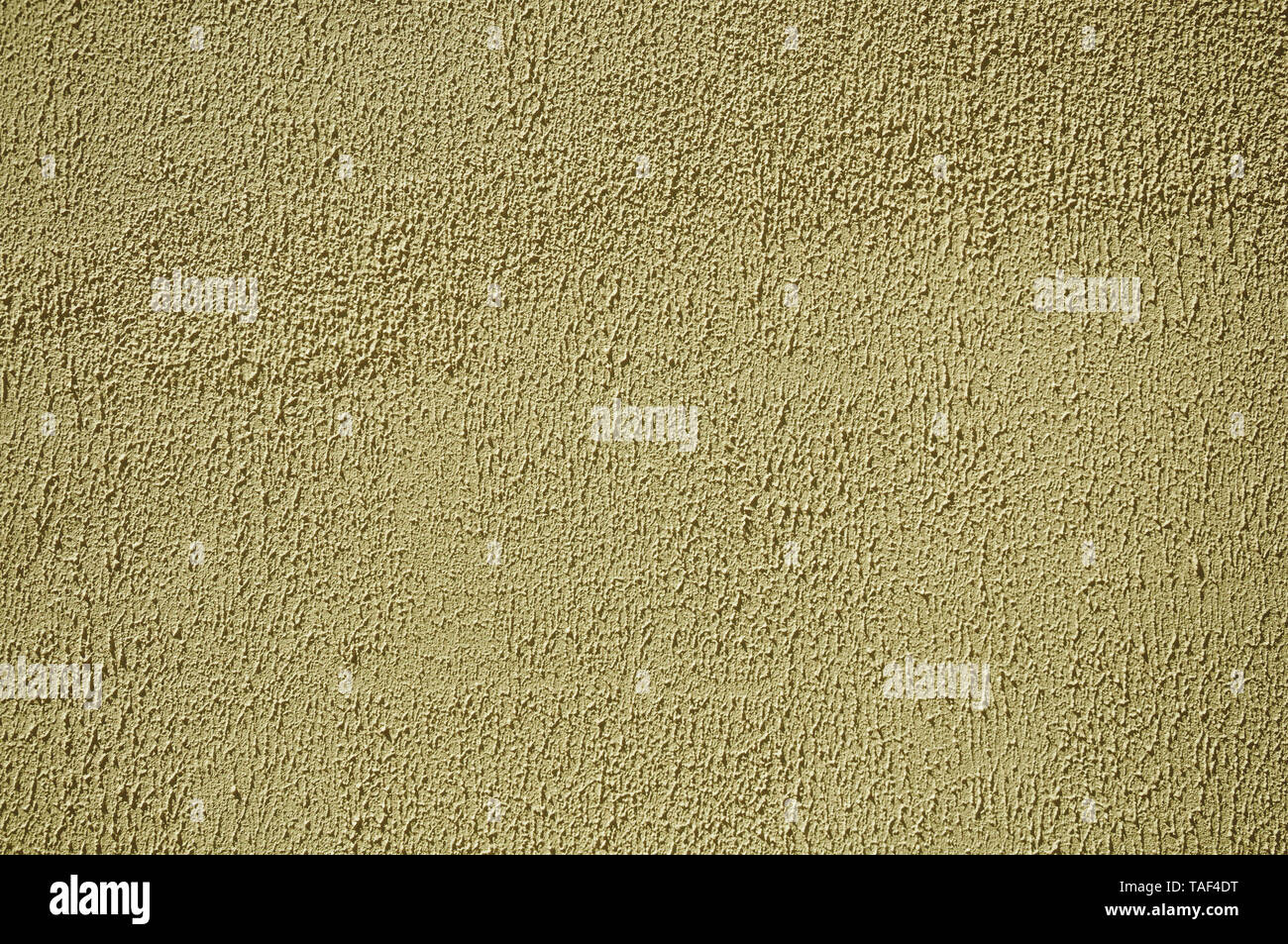 Wall plaster covered by yellow rough paint, forming a singular ...