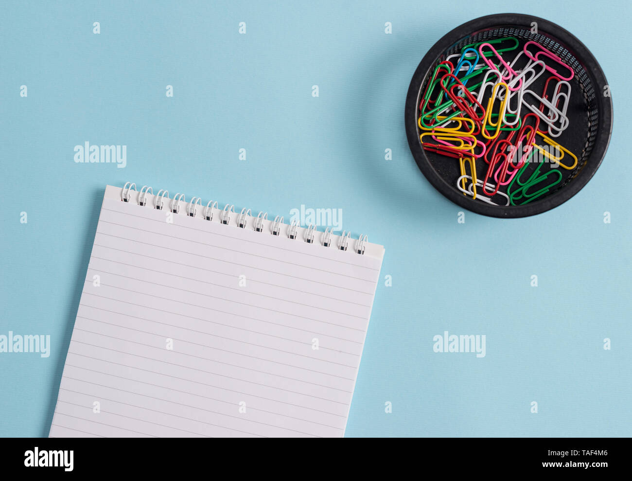 Blank empty notebook and stationary placed above pastel colour backdrop ...