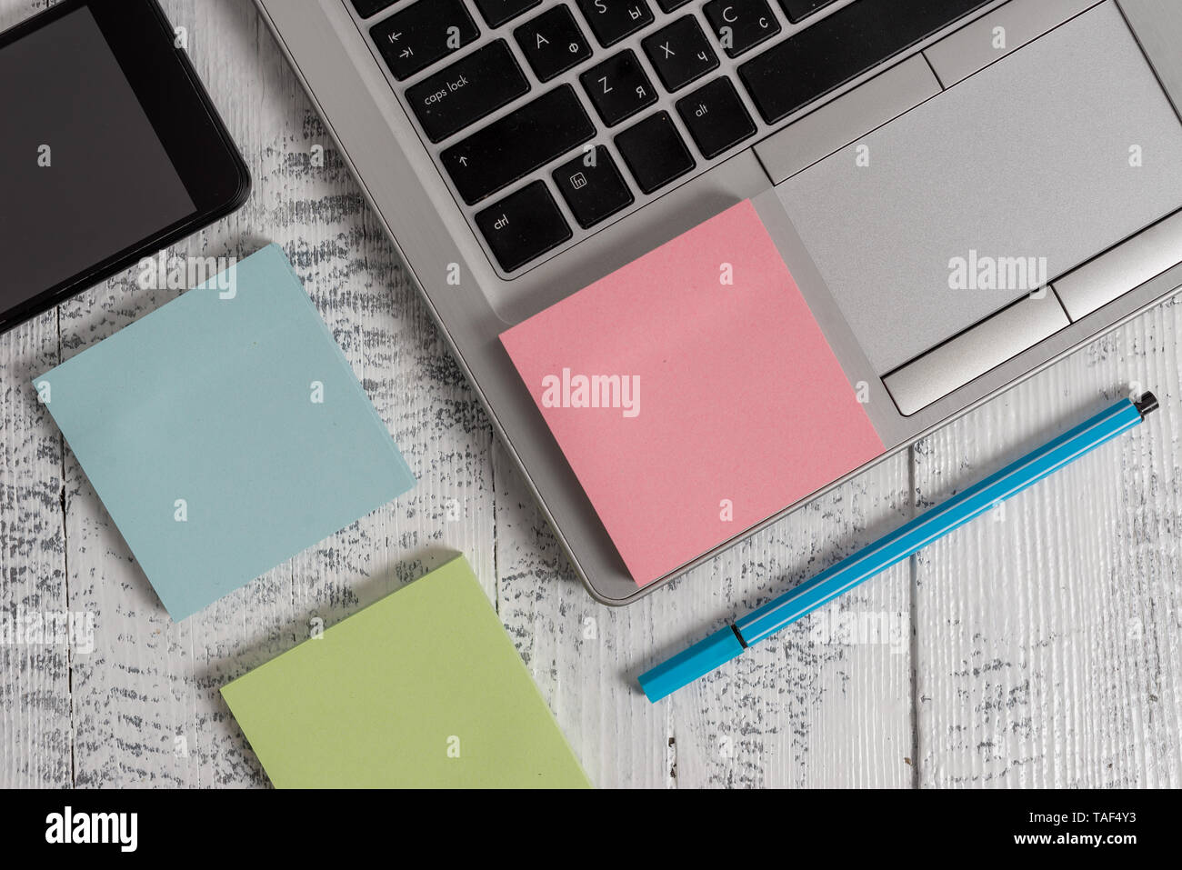 Metallic laptop sticky note pads pen smartphone lying old wooden table ...