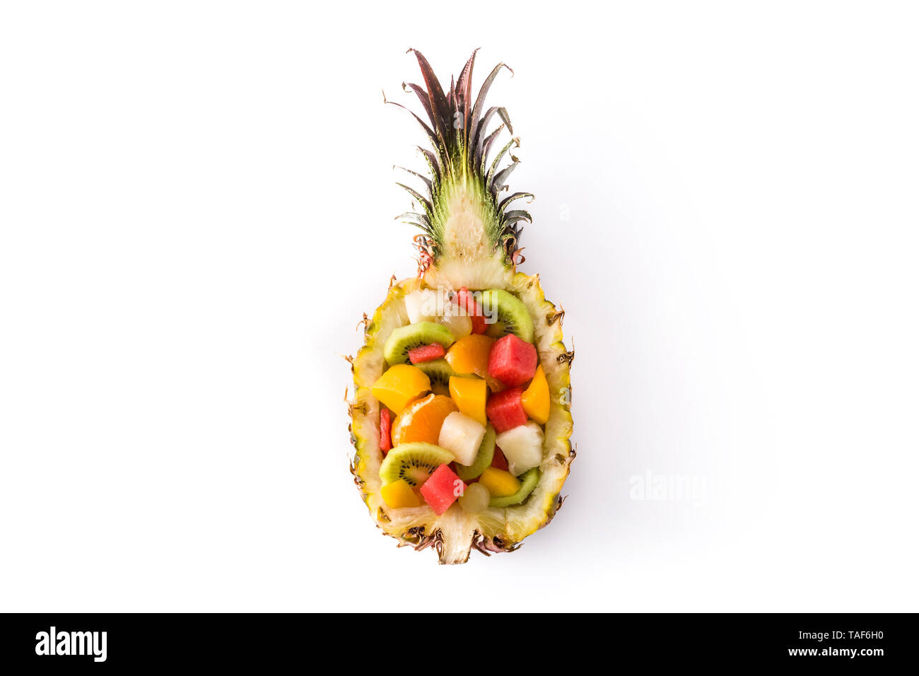 Mix fruit served inside pineapple isolated on white background. Top ...