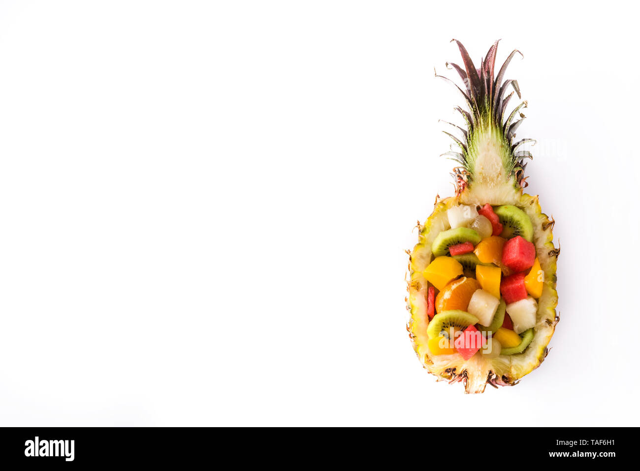 Mix fruit served inside pineapple isolated on white background. Top ...