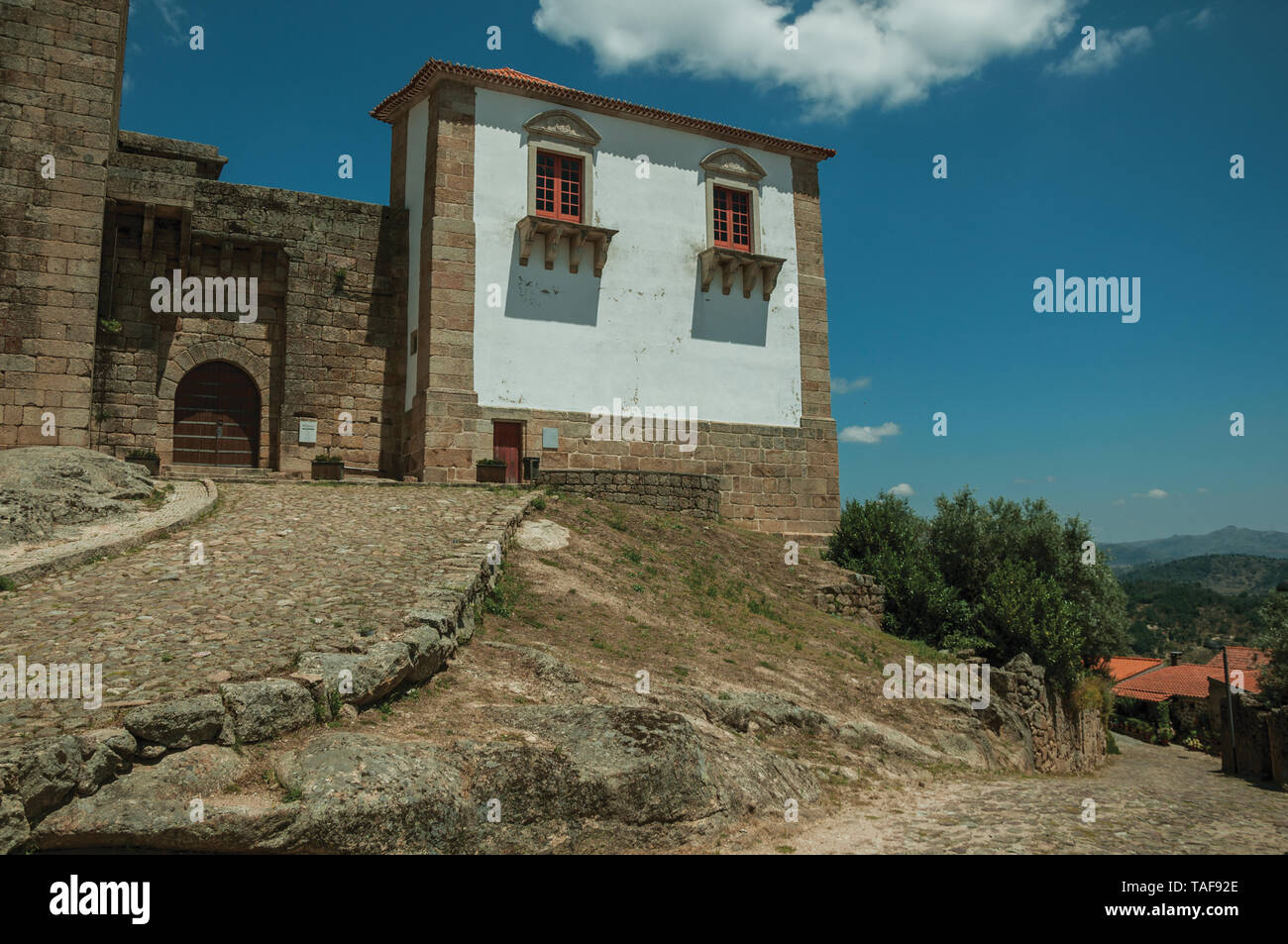 Stone walls and square tower over rocky hill on the facade of medieval ...