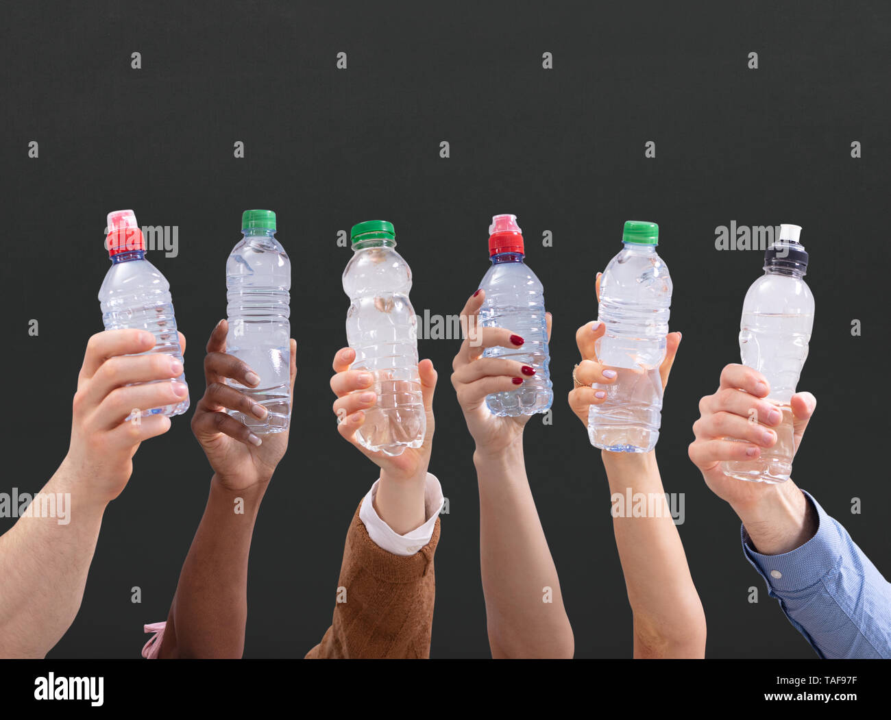 Group Of Different People Holding Water Bottles In A Row Against Green ...