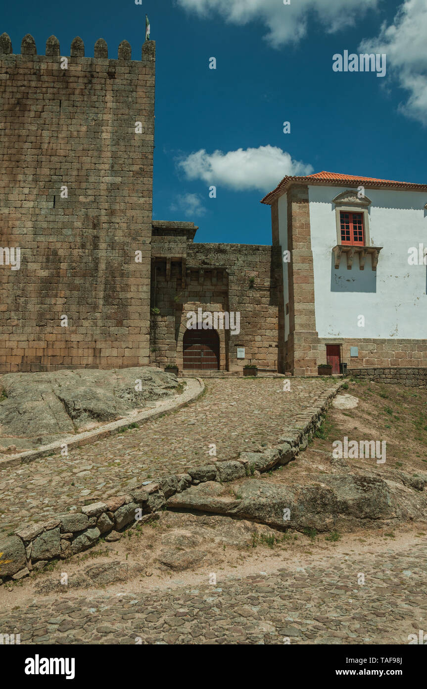 Stone walls and square tower over rocky hill on the facade of medieval ...