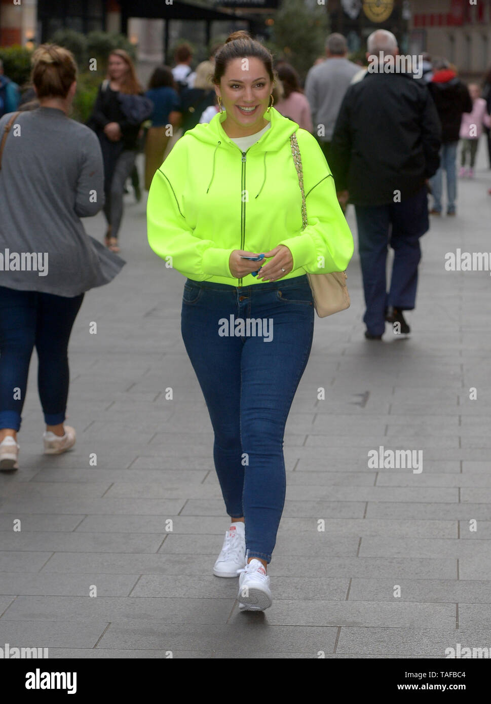 Kelly Brook smiles for the camera while walking outside Global Radio ...