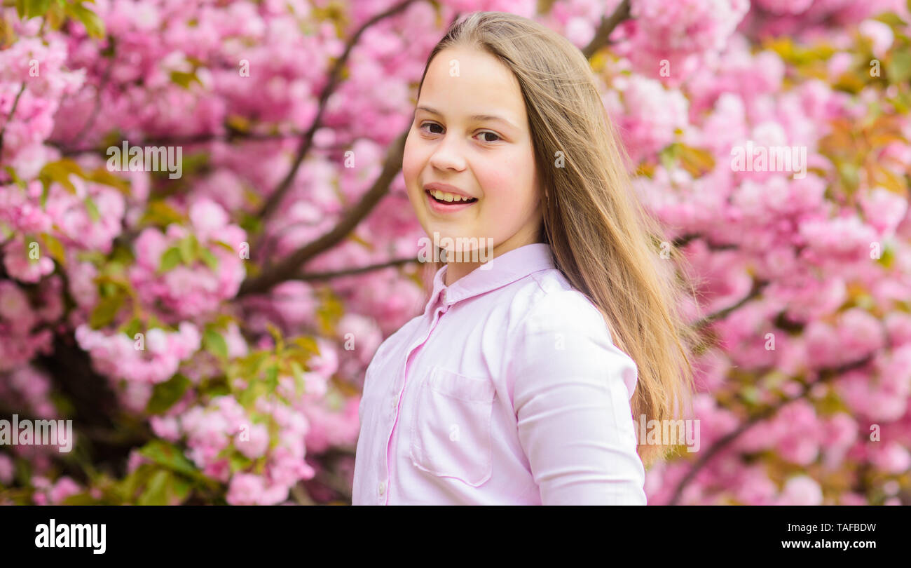 Little girl enjoy spring. Kid on pink flowers of sakura tree background ...