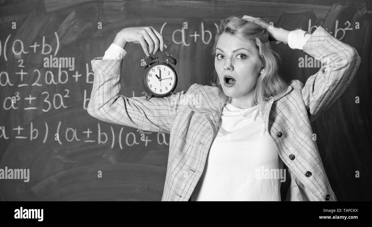 She care about discipline. Woman teacher hold alarm clock. Lessons ...