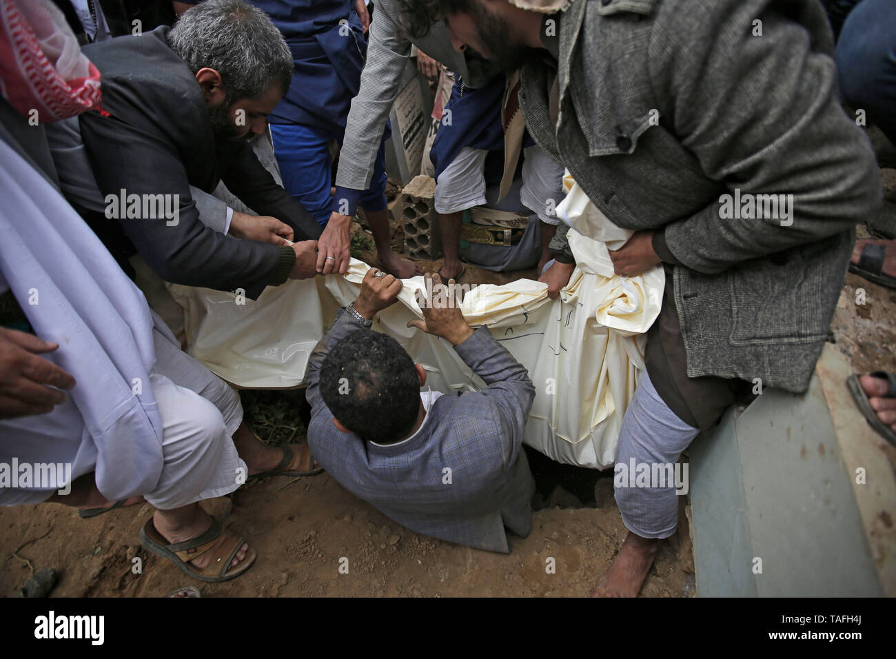 Sanaa, Yemen. 24th May, 2019. Yemeni people bury the bodies of the ...
