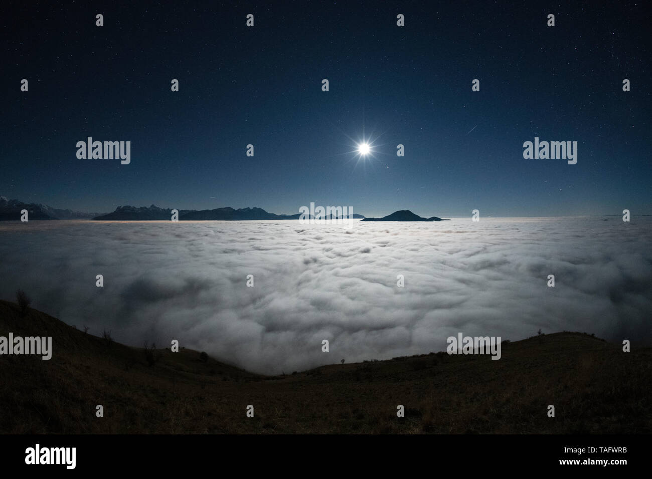Sea of cloud and moon, night, on the Prealps. The Mole mountain and the ...