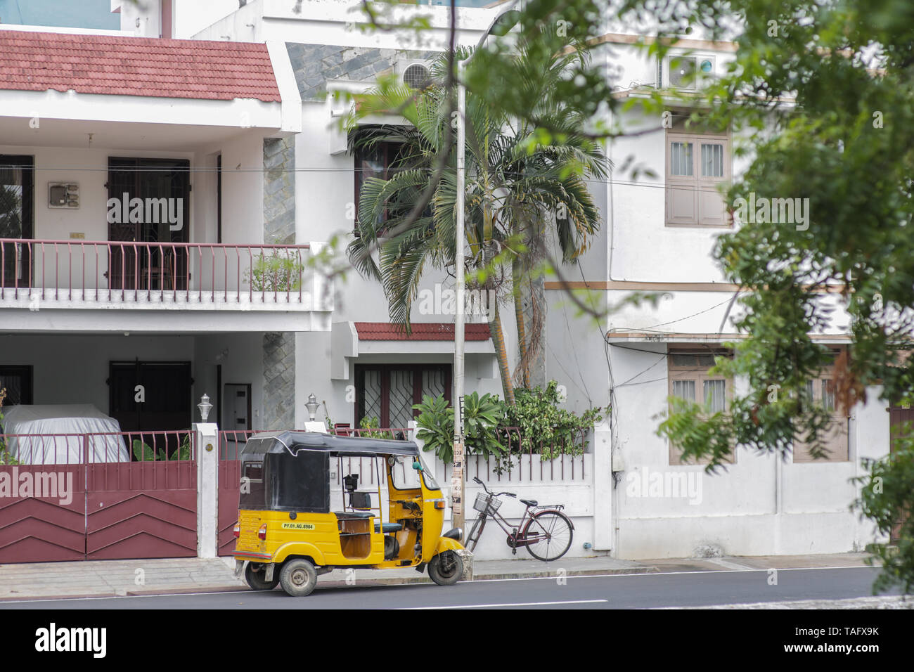 A parked auto rickshaw in front of a house on a street in the former ...