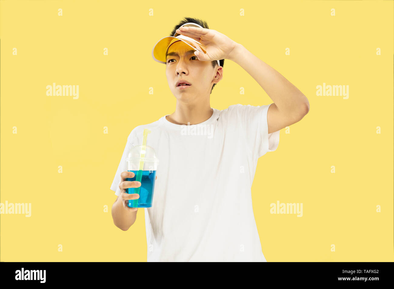 Korean young man's half-length portrait on yellow studio background ...