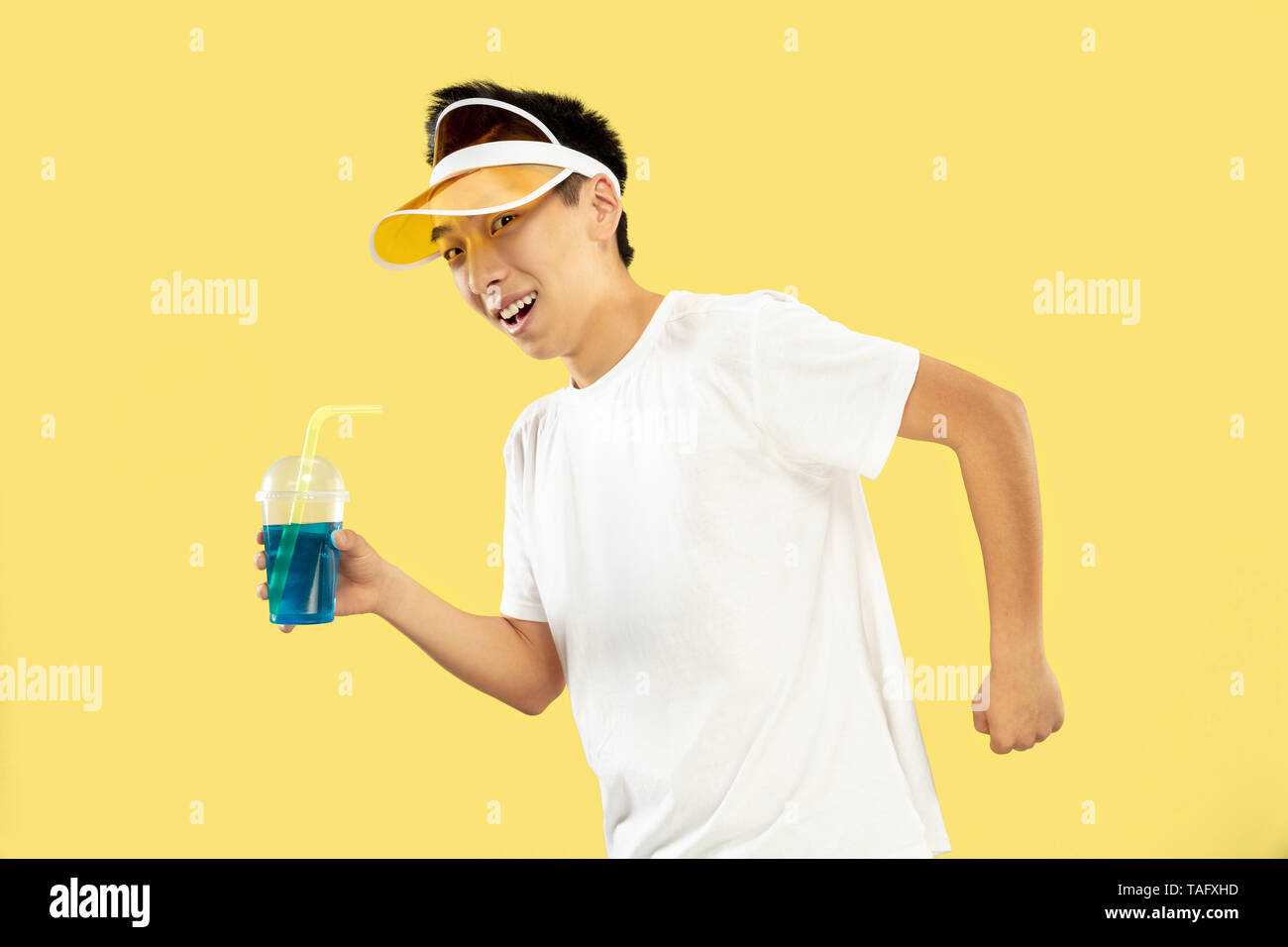 Korean young man's half-length portrait on yellow studio background ...