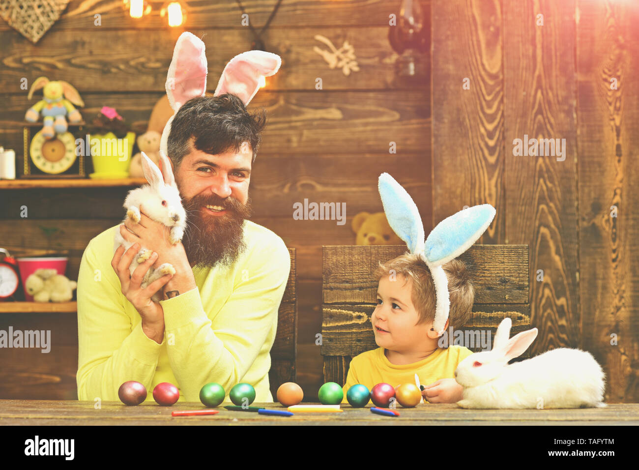 Father and kid painting Easter eggs. Rabbit's family with bunny ears ...