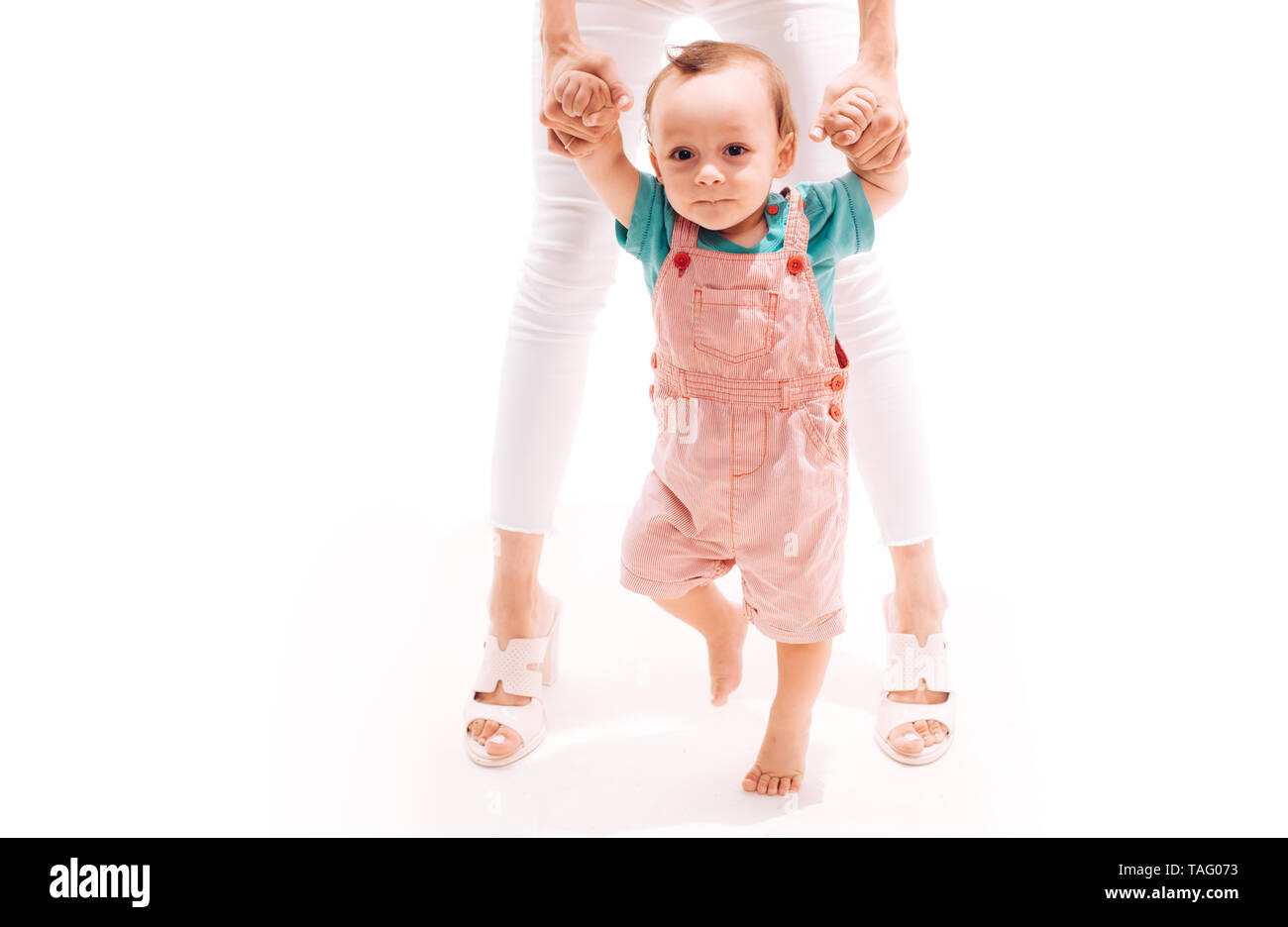 Helping baby learn to walk. Small child walking with help, motor skills ...