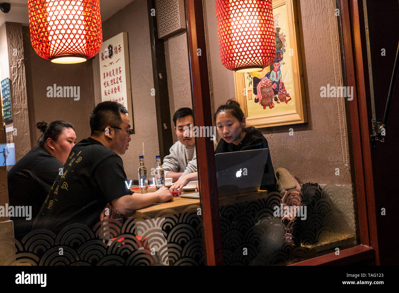 Oriental group of four 25-35 years in a Chinatown Chinese restaurant ...