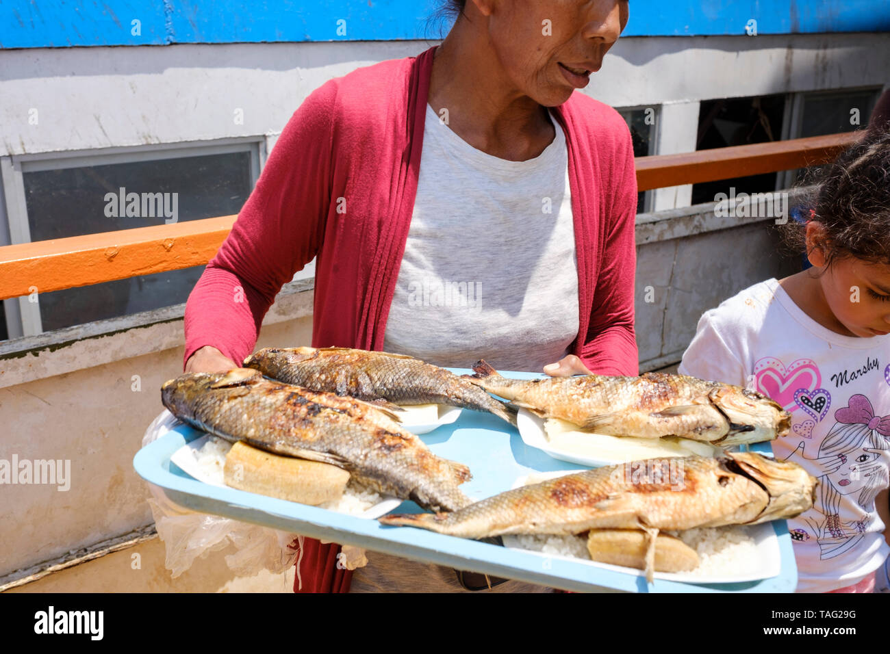 Woman selling fried fish on the ferry on the route Iquitos-Pucallpa at ...