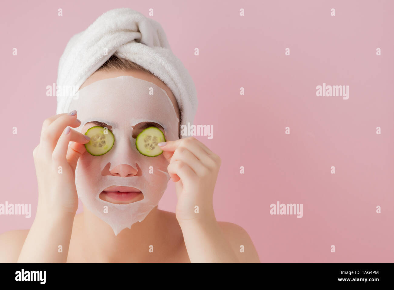 Beautiful young woman is applying a cosmetic tissue mask on a face with ...