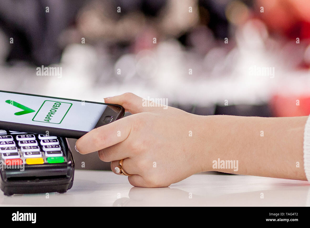 POS terminal, Payment Machine with mobile phone on store background ...