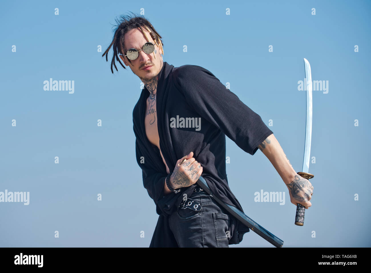 Samurai and japan weapon. Man with katana sword standing on blue sky ...