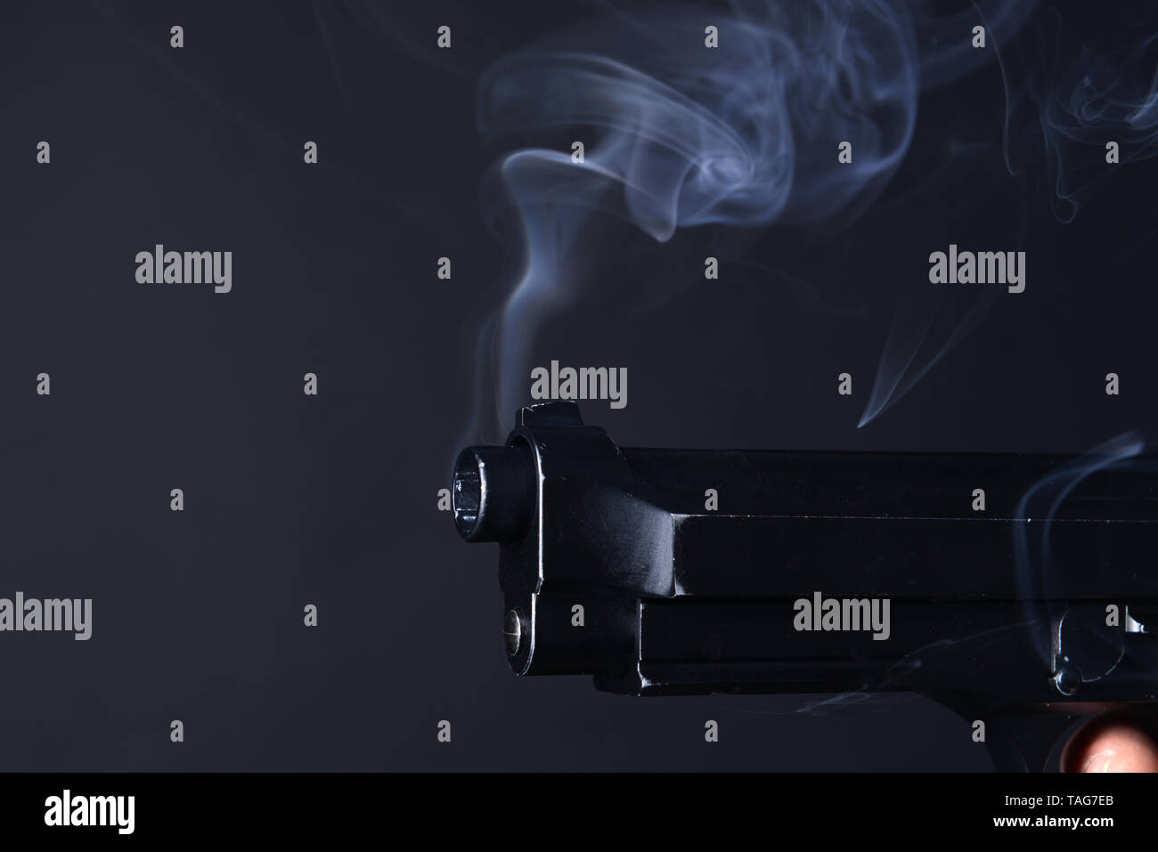 Smoking gun on dark background Stock Photo - Alamy