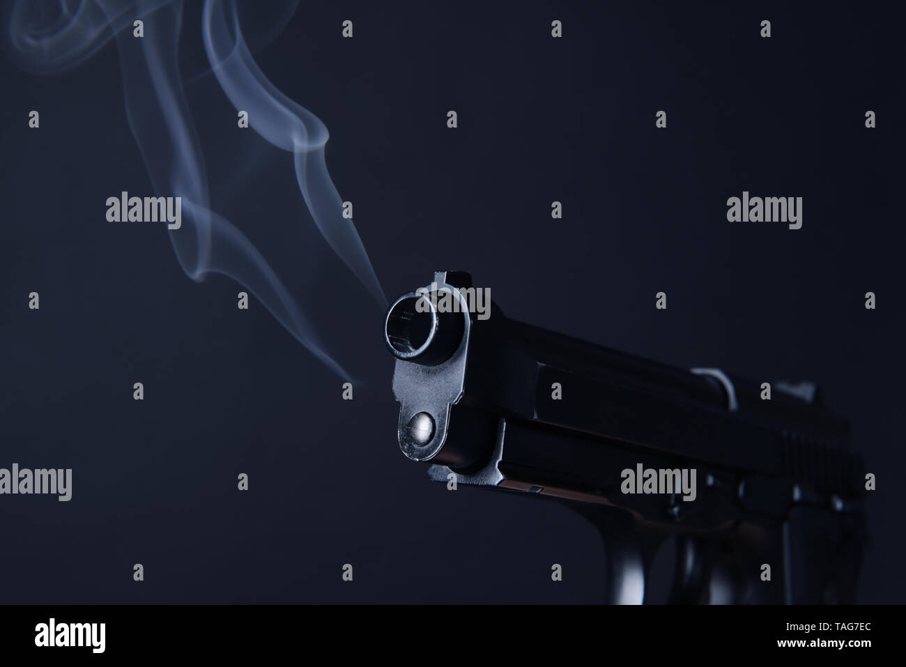 Smoking gun on dark background Stock Photo - Alamy