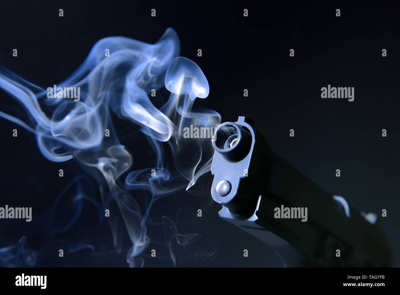 Smoking gun on dark background Stock Photo - Alamy