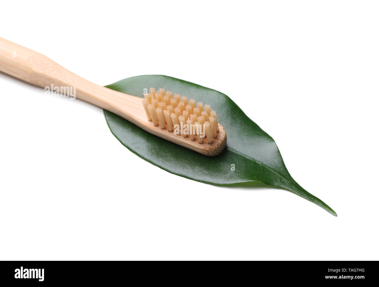 Wooden toothbrush and green leaf on white background. Ecology concept ...