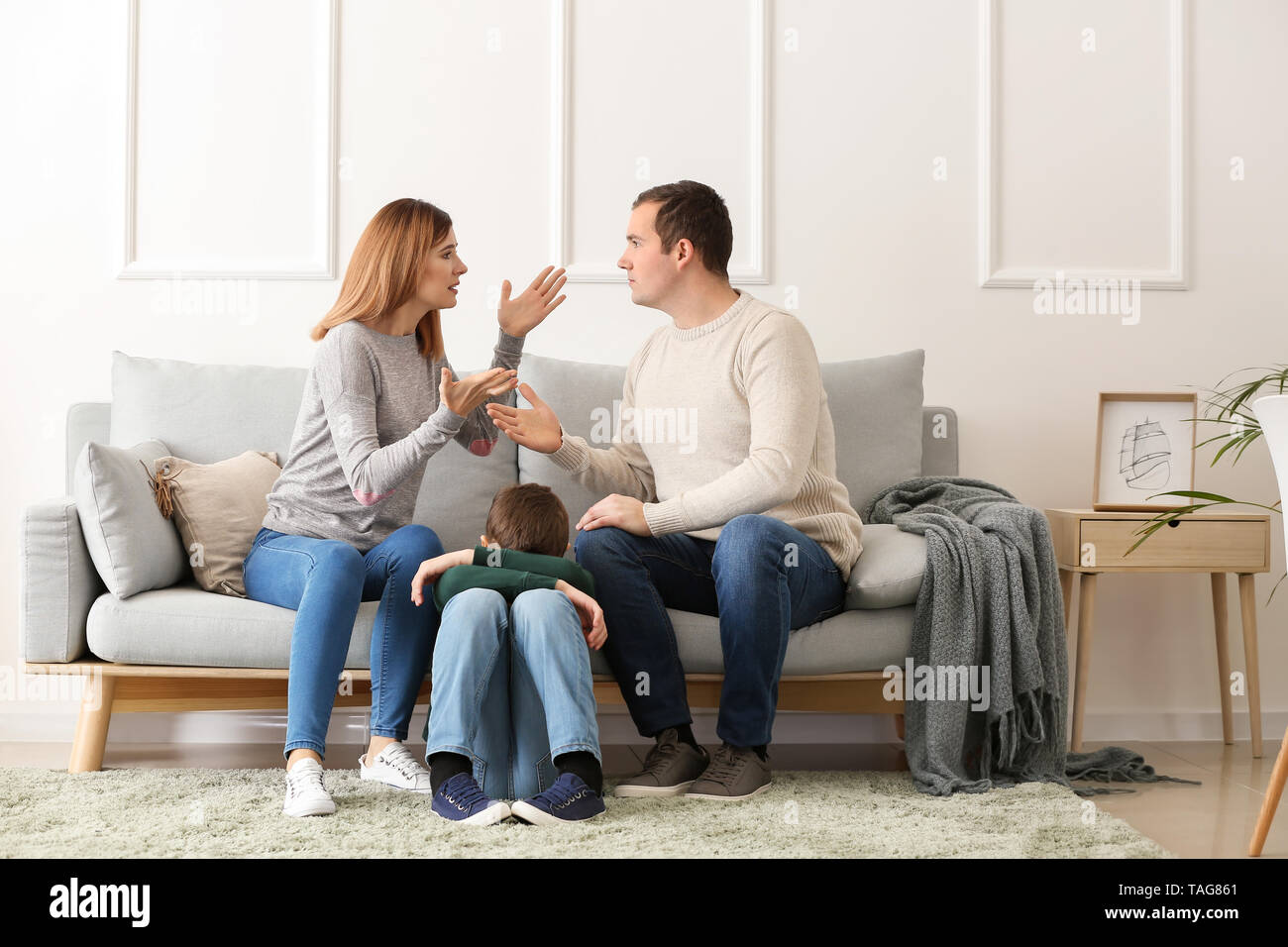Sad little boy with his quarreling parents at home Stock Photo - Alamy