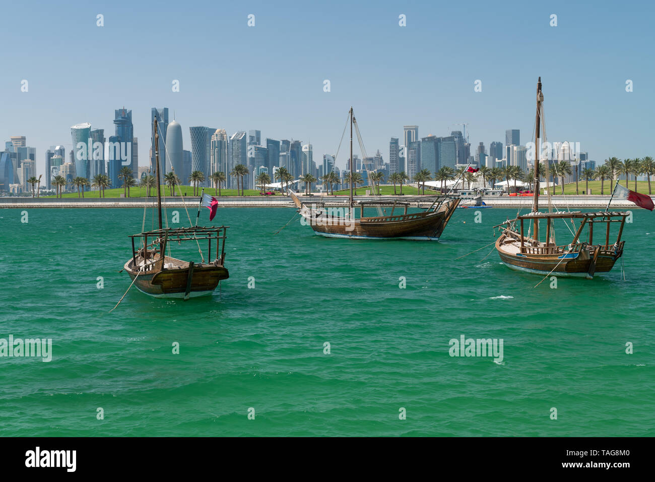 Old fisherman ships in the water in the background the West Bay of Doha ...