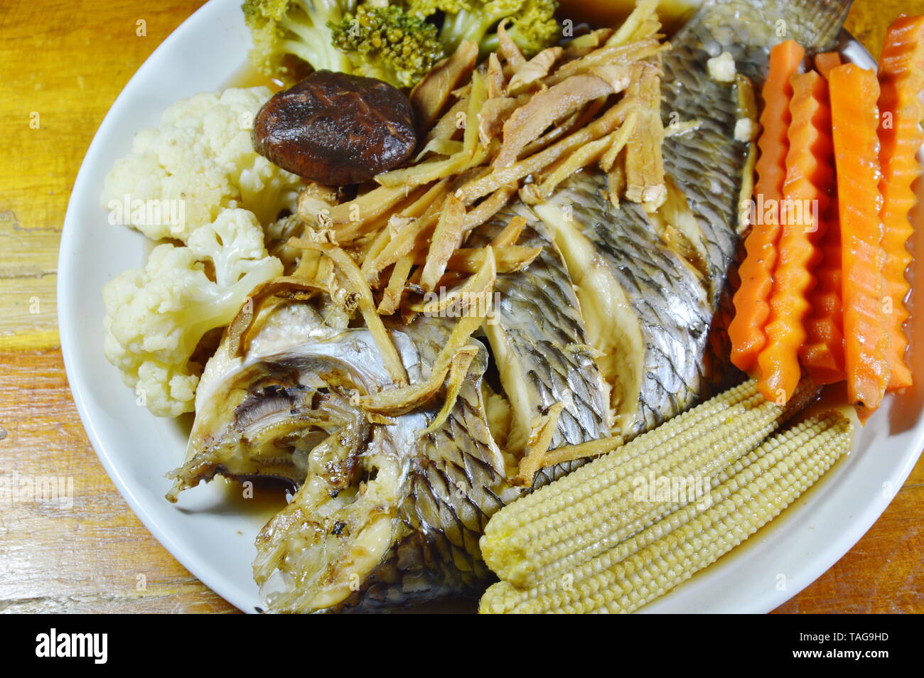 steamed mango fish with slice ginger and vegetable in soy sauce on dish ...
