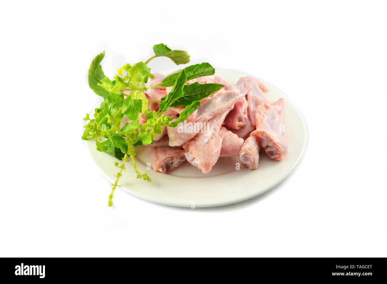 Fresh raw chicken wing on plate and holy basil isolated on white ...