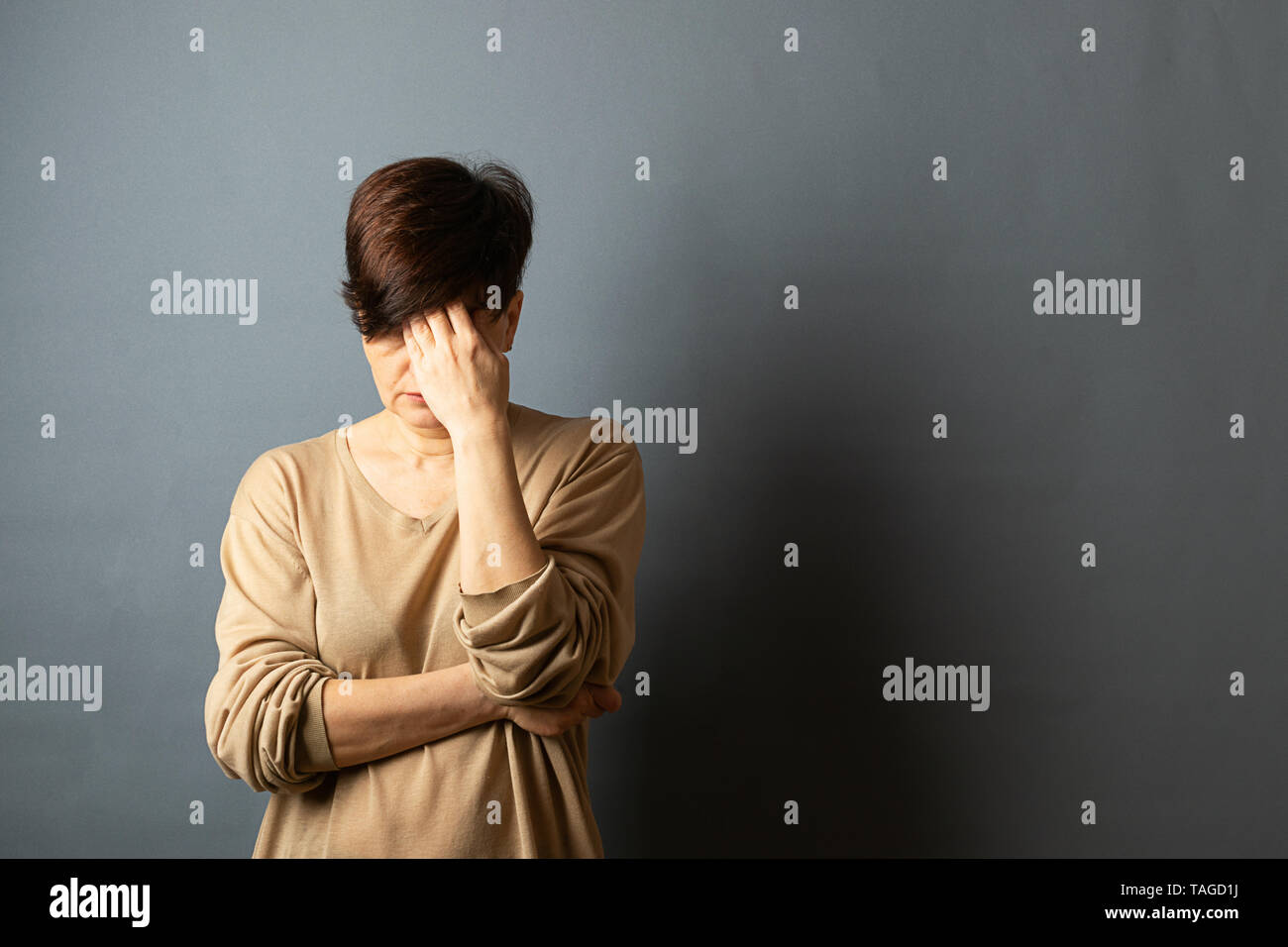Portrait of a young woman with a short haircut on a gray blank ...