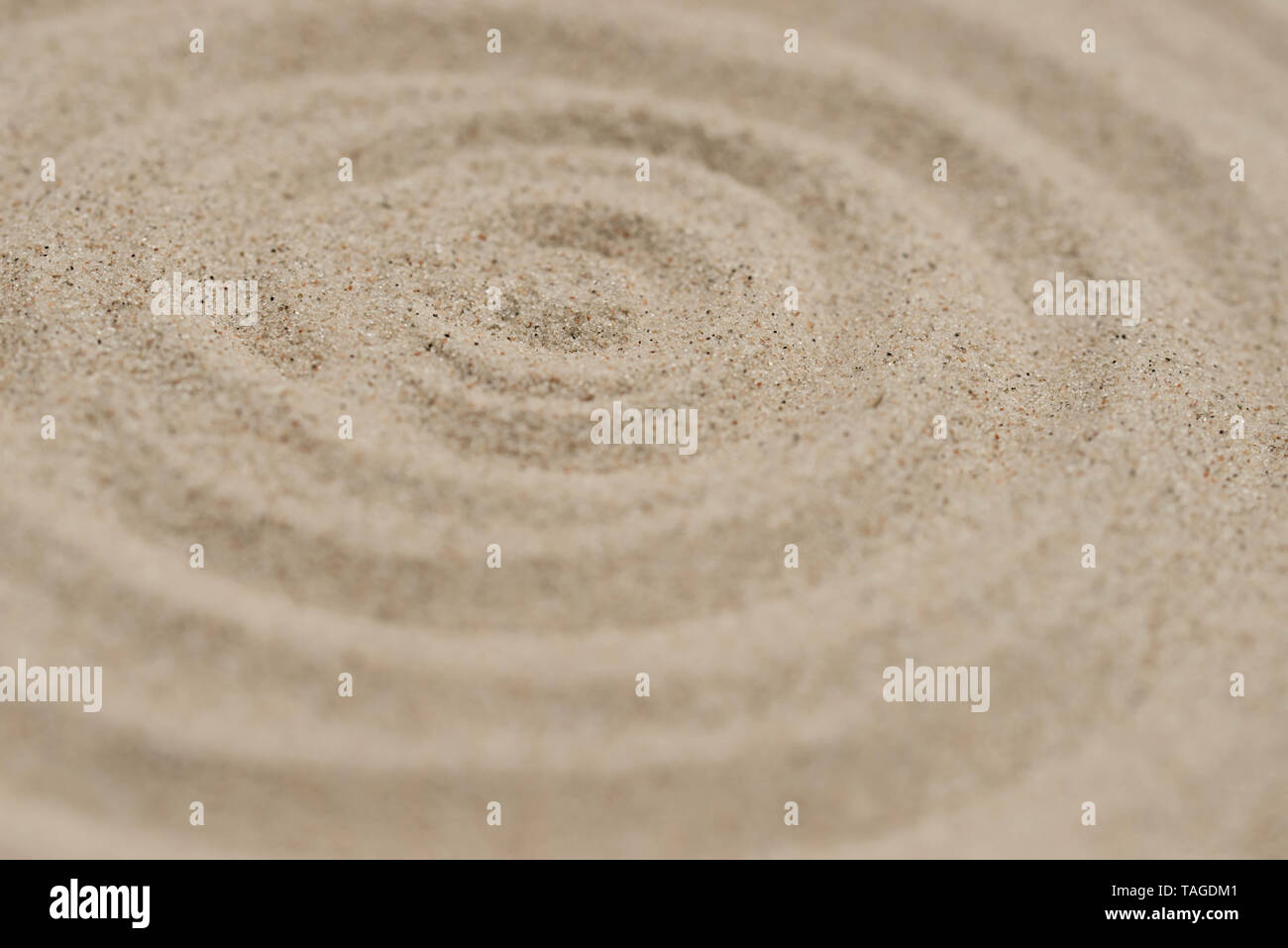 concentric circles pattern on natural sand texture background closeup ...