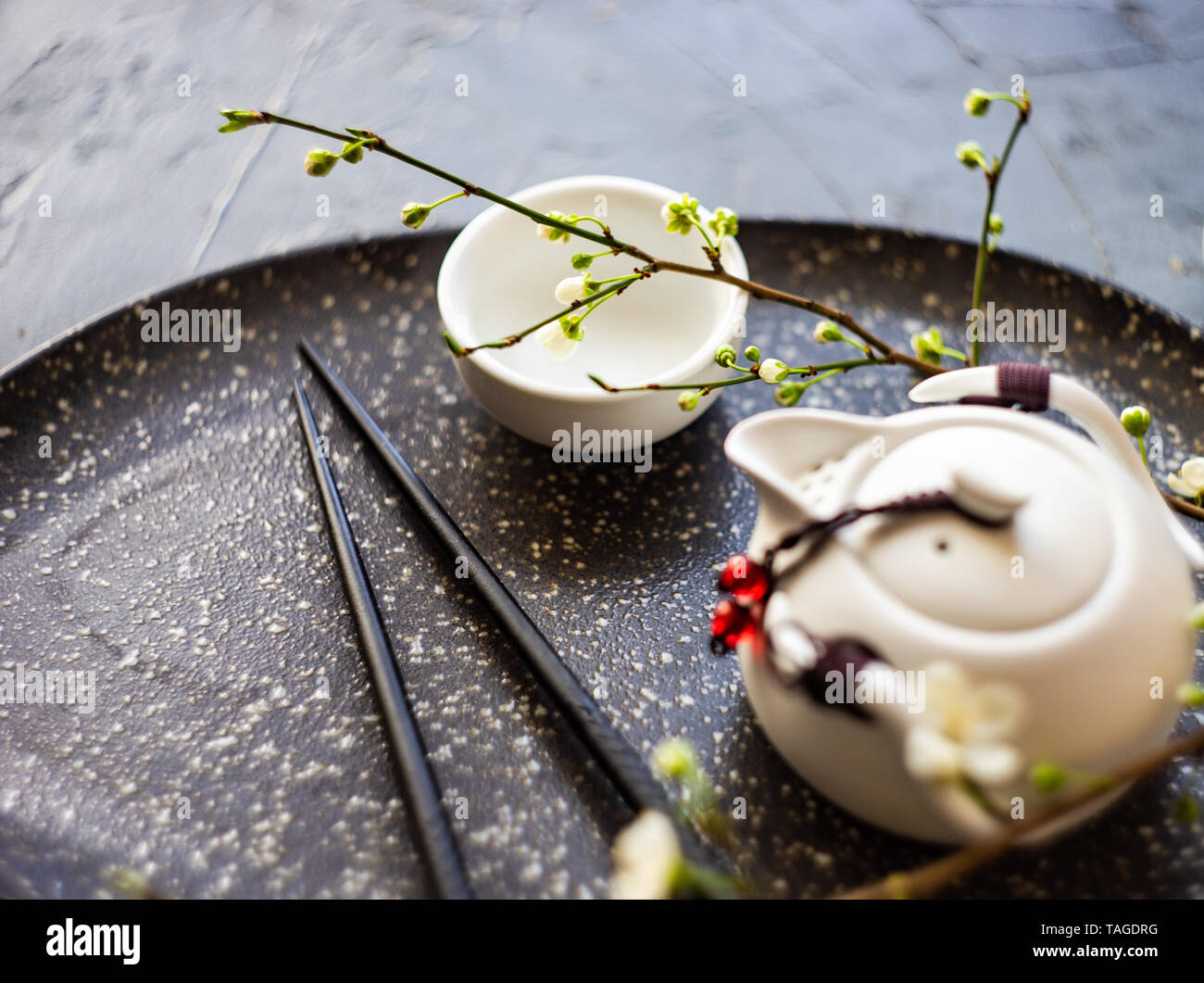 Asian style green tea set and blooming peach tree branch on wooden ...
