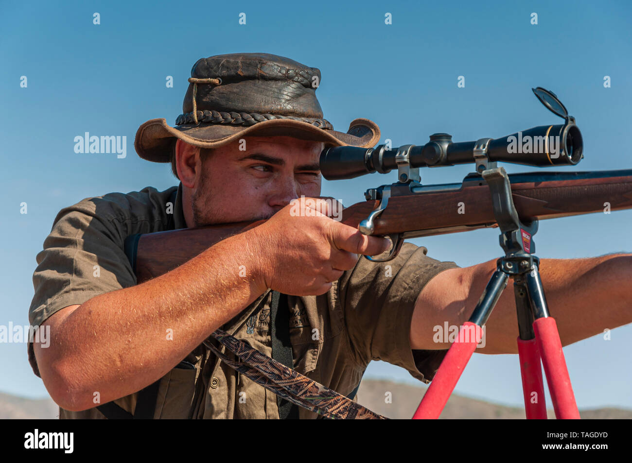 A close-up of a professional hunter taking aim at a target on a game ...
