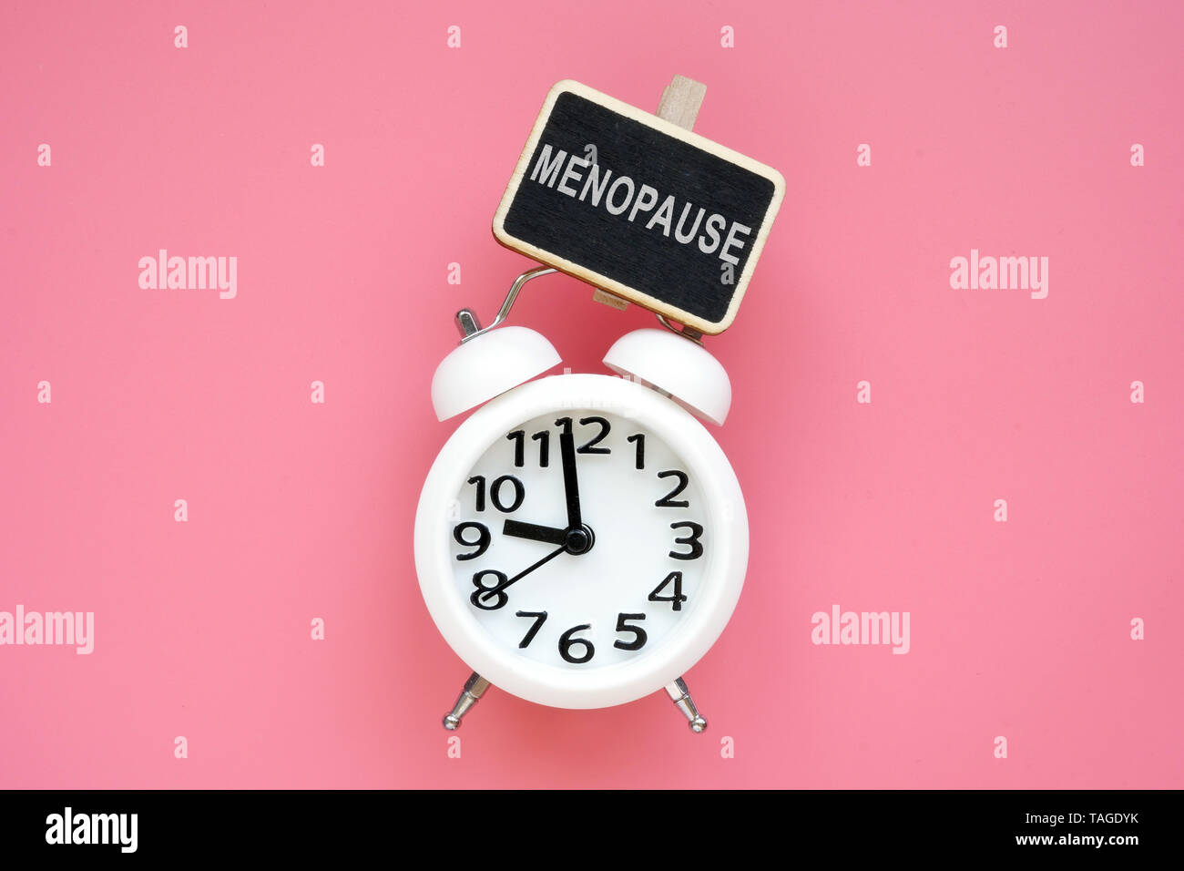 Alarm clock and word menopause on a pink background Stock Photo - Alamy