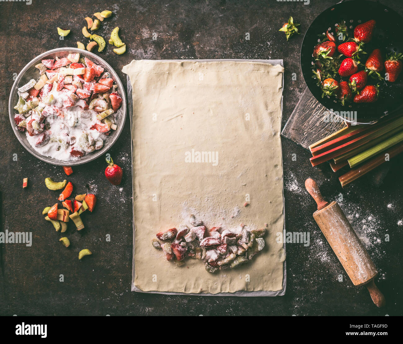 Sheet of dough with diced rhubarb and strawberries ingredients for ...