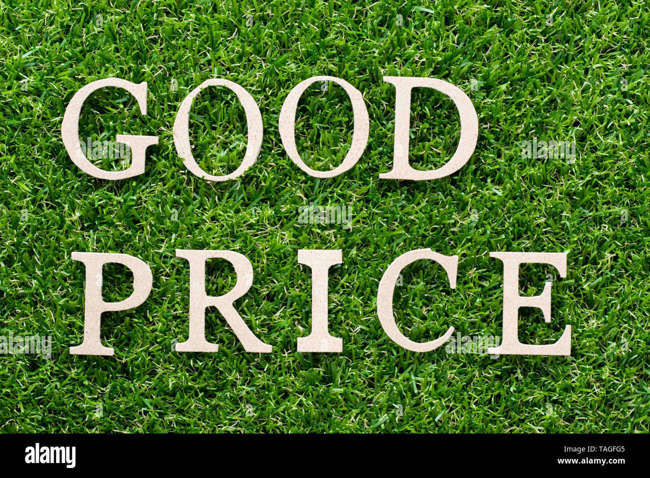 Wood alphabet in word good price on artificial green grass background ...