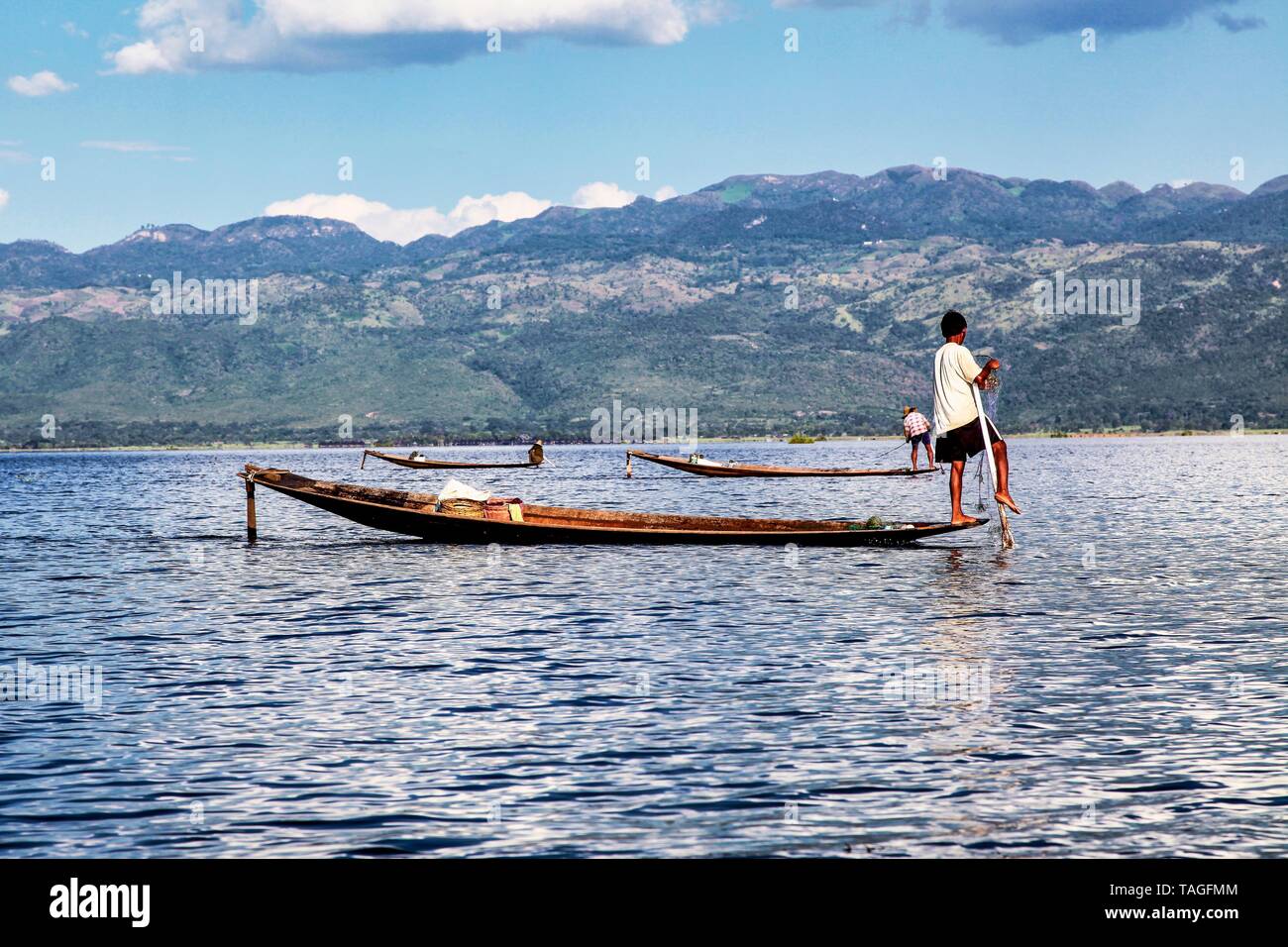 Fisherman rowing boat by leg on Inle Lake, Myanmar. Inle Lake is famous ...