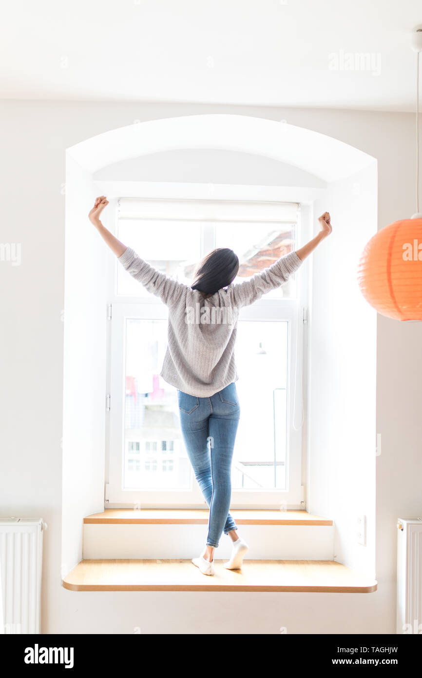 Young pretty woman stretching near big windows at home, back view Stock ...